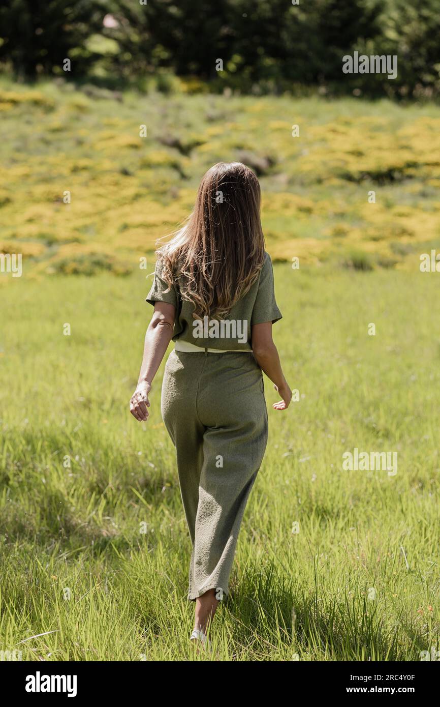 Full body back view of unrecognizable female in casual clothes walking ...