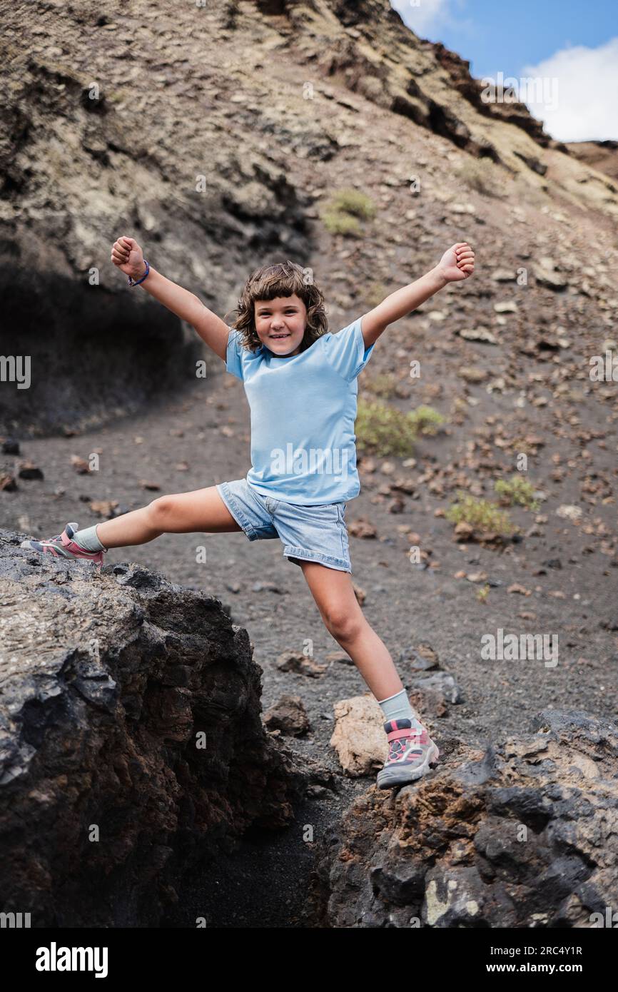 Happy preteen kid in casual clothes looking at camera while standing ...