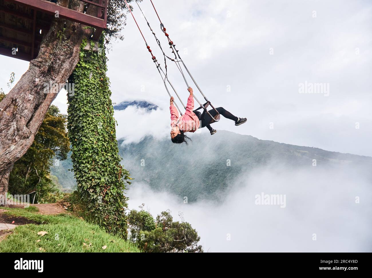 Side view of cheerful young female on rope of treehouse in Casa del ...