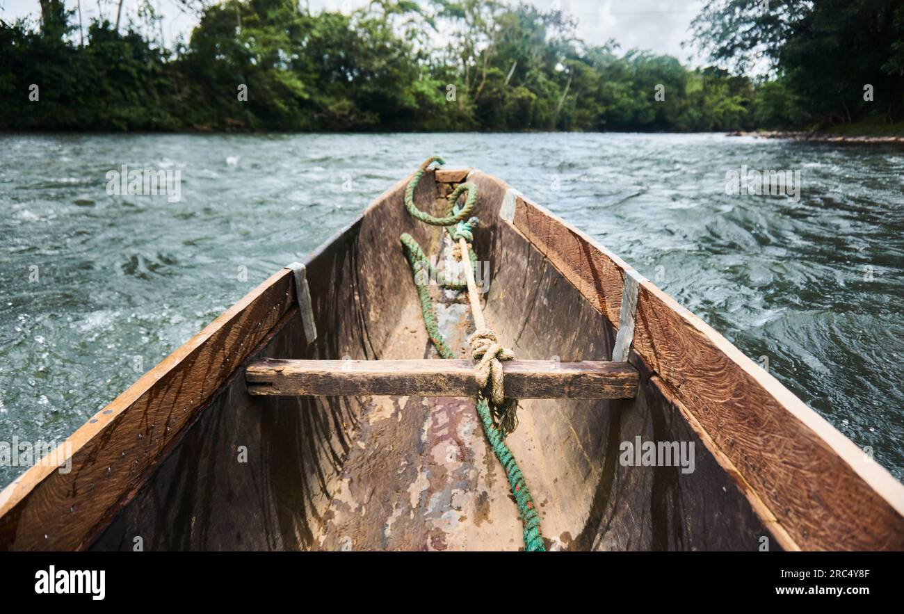 Old wooden boat with rope tied from bow to wooden plank floating in ...