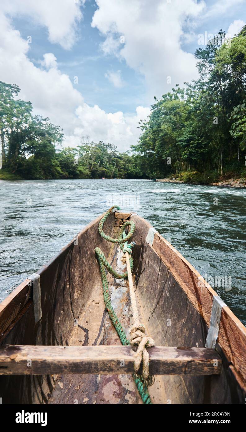 Old wooden boat with rope tied from bow to wooden plank floating in ...