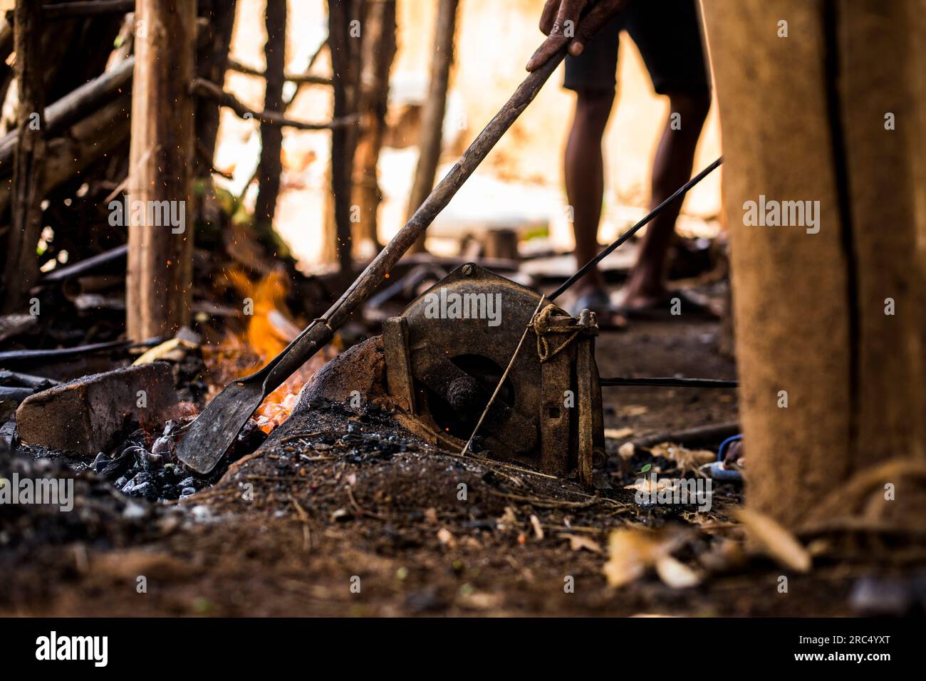 Crop anonymous person using spade in gathering and burning leaves and ...