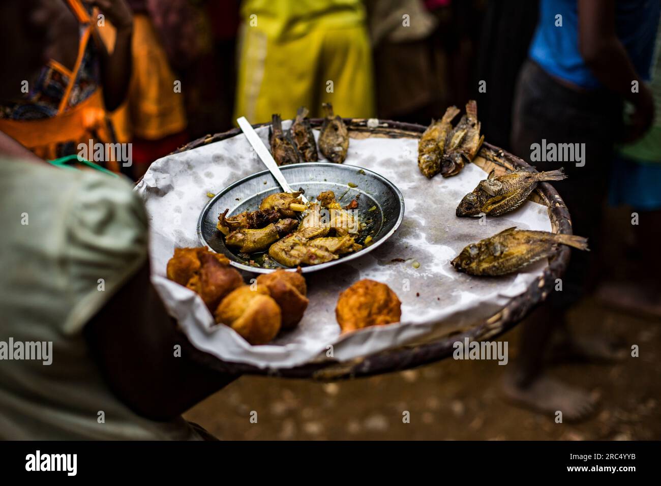 Crop anonymous African chef with delicious roasted chicken and fried ...