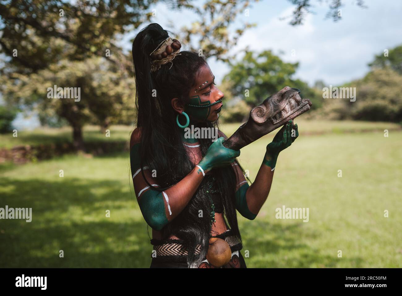 Portrait of young female Mayan warrior in traditional costume and body ...