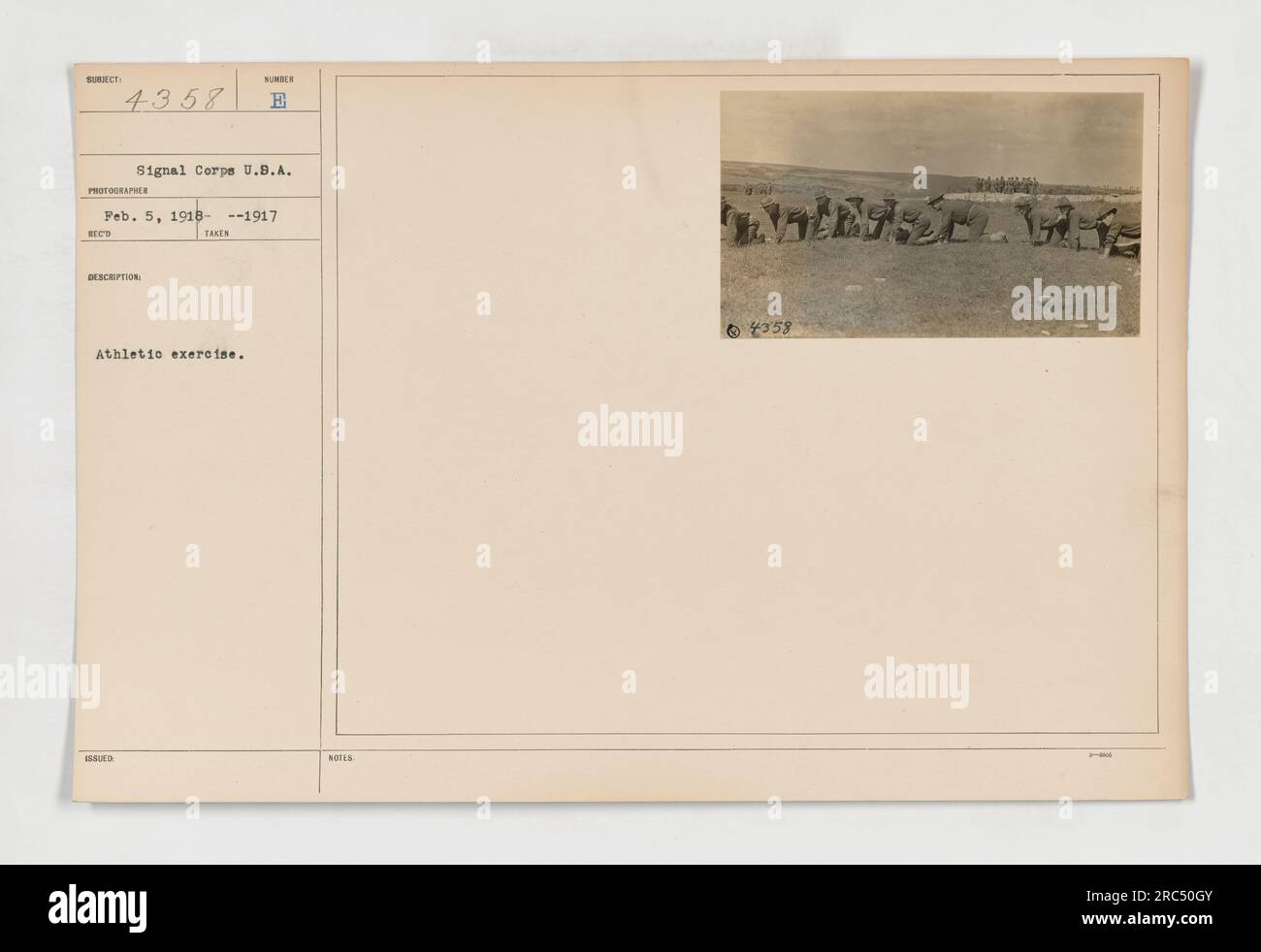 American soldiers participate in an athletic exercise during World War One. This photograph ...