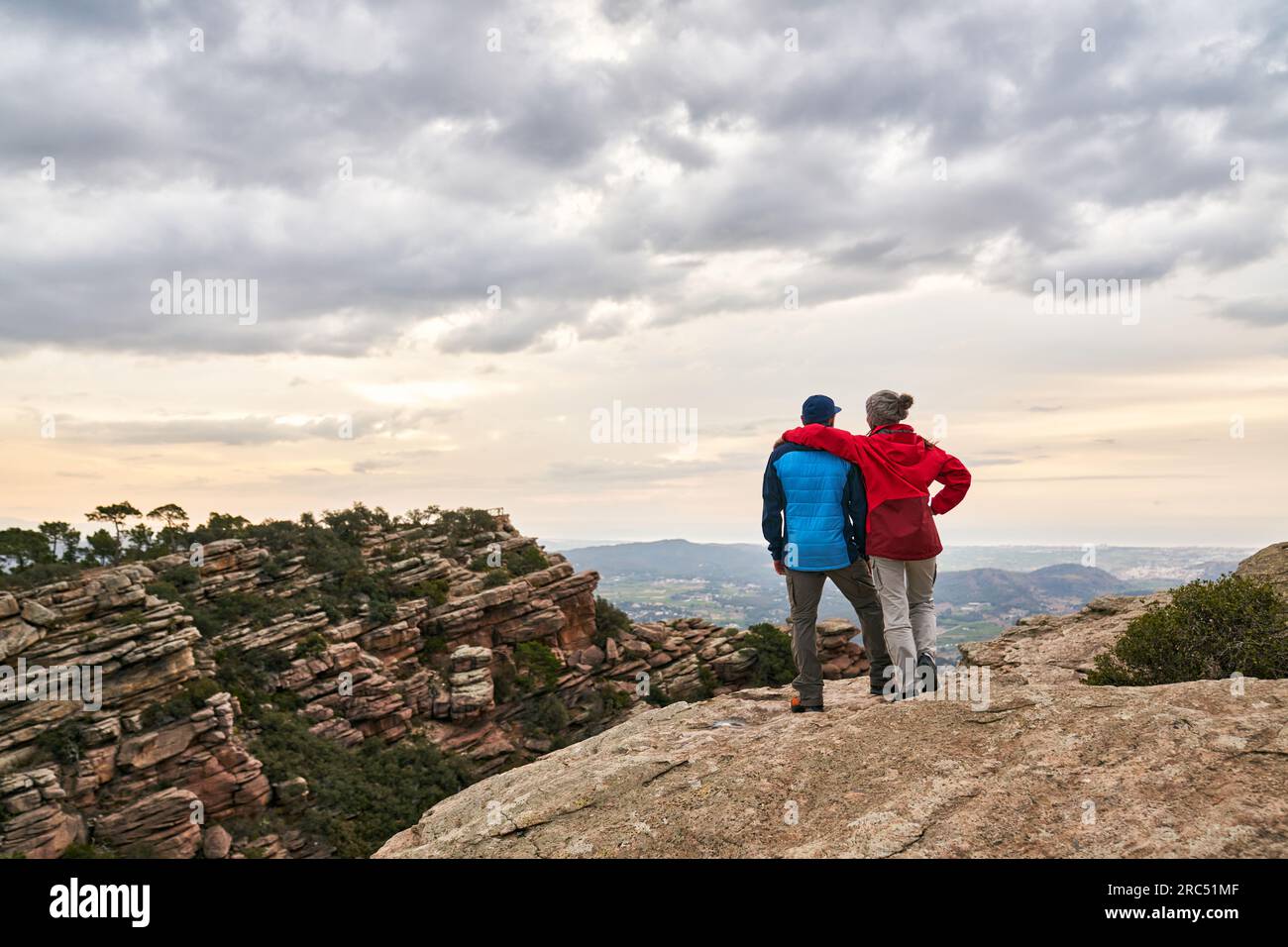 Back view of unrecognizable wife with backpack hugging on husband on ...