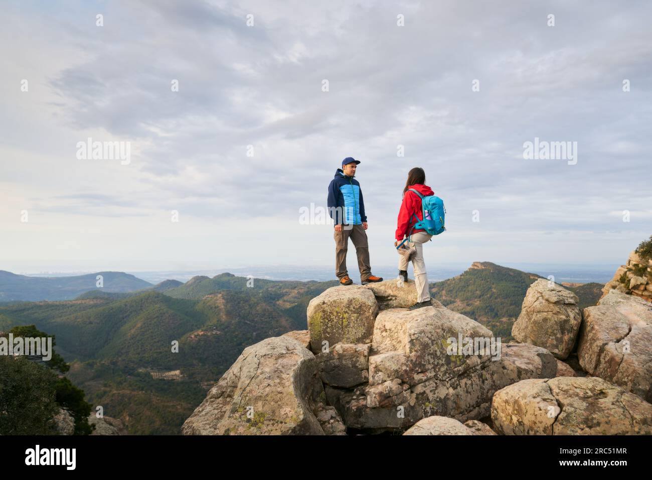 Side view of wife with backpack standing with husband on top of ...