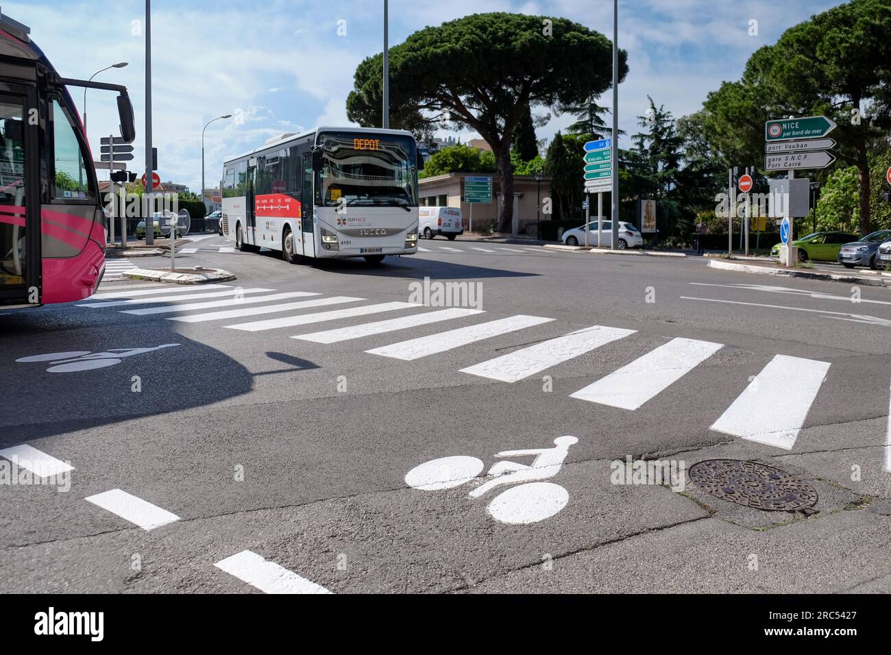 Buses, road and cyclist sign in Antibes, Cote d'Azur, France Stock ...