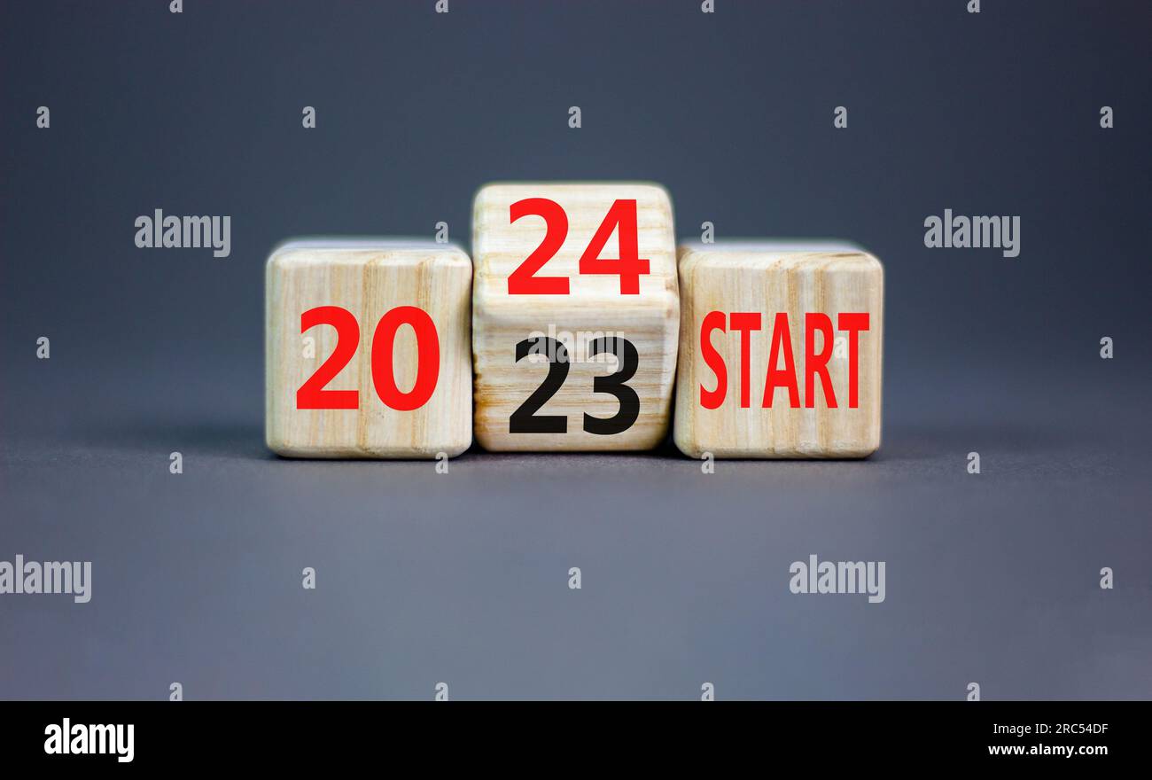 2024 start new year symbol. Businessman turns a wooden cube and changes words Start 2023 to ...