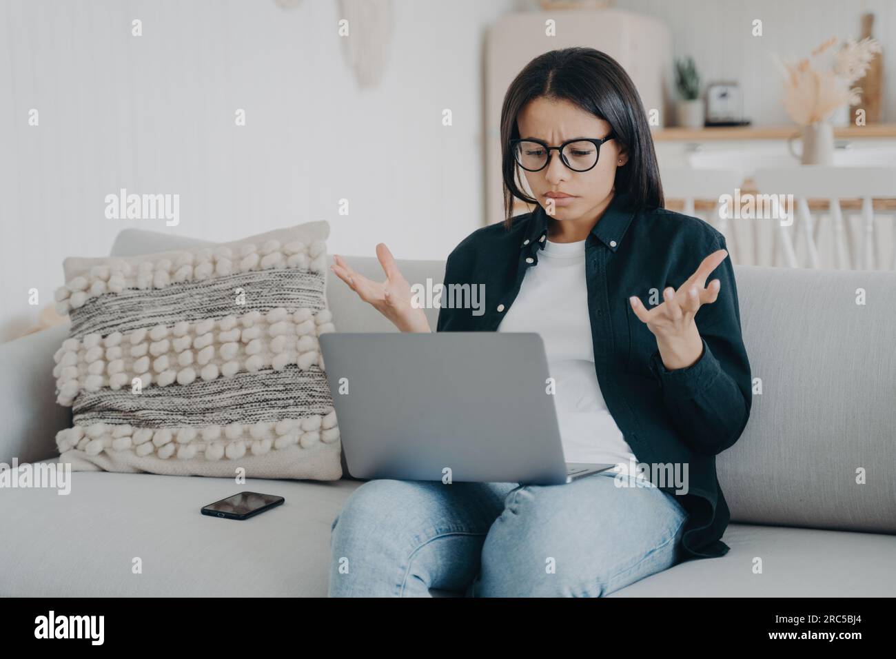 Angry woman struggles with laptop, forgets password. Unhappy, reads bad ...