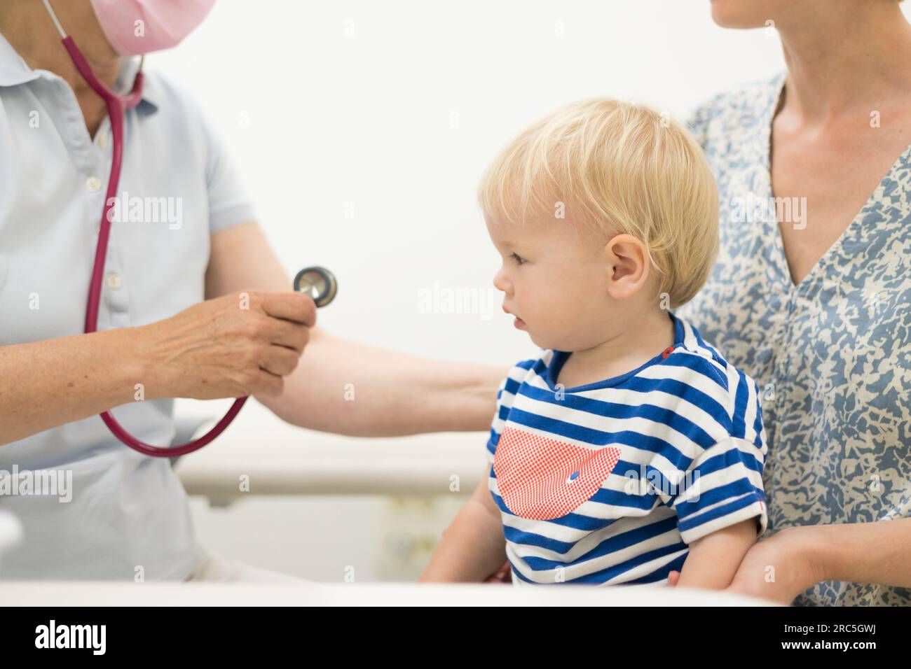 Infant baby boy child being examined by his pediatrician doctor during ...