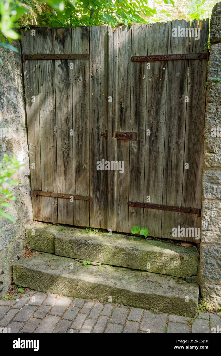 a grey weathered wooden gate on a stone wall, double-winged Stock Photo ...