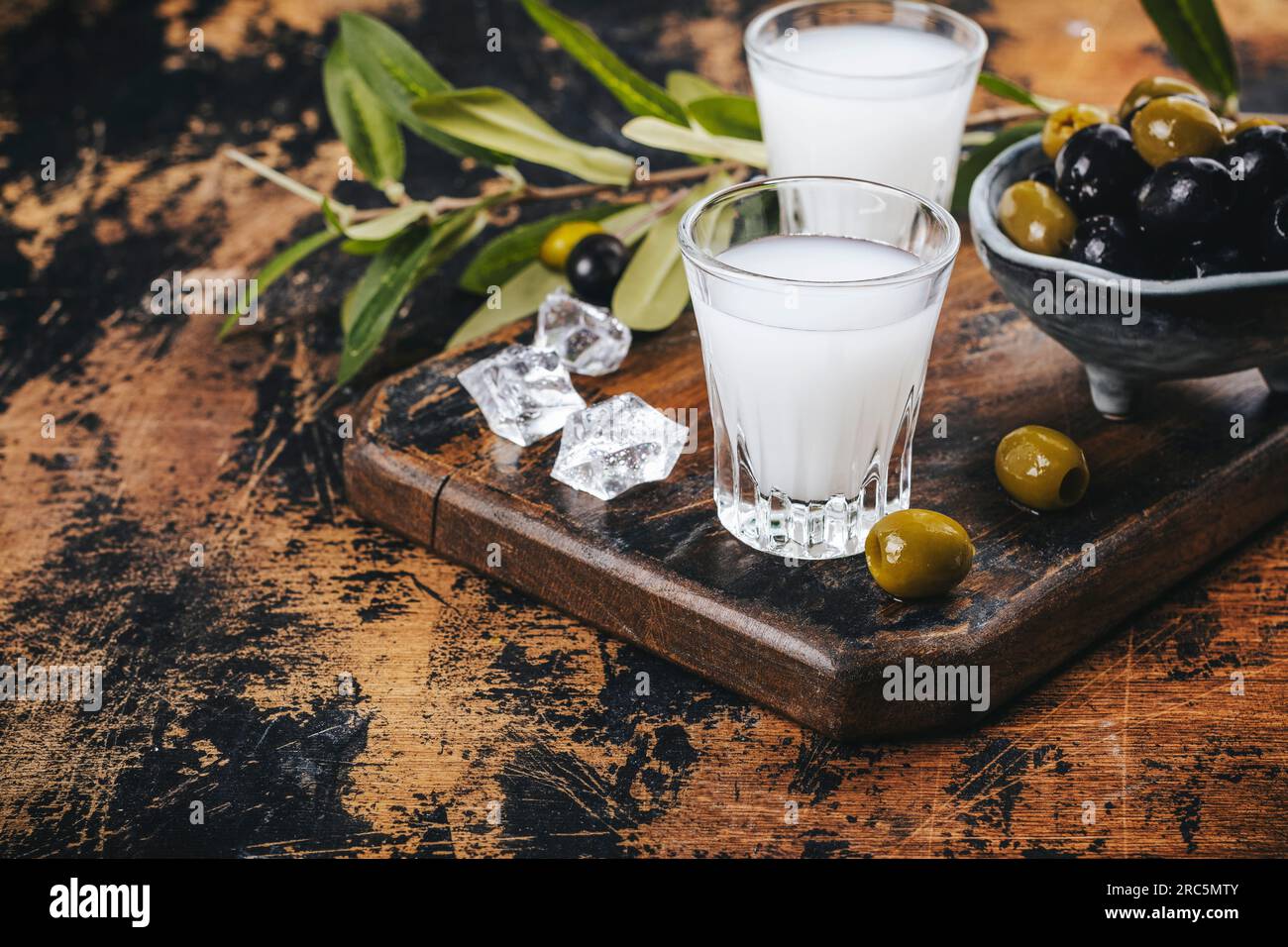 Traditional greek vodka ouzo and marinated olives on rustic wooden ...