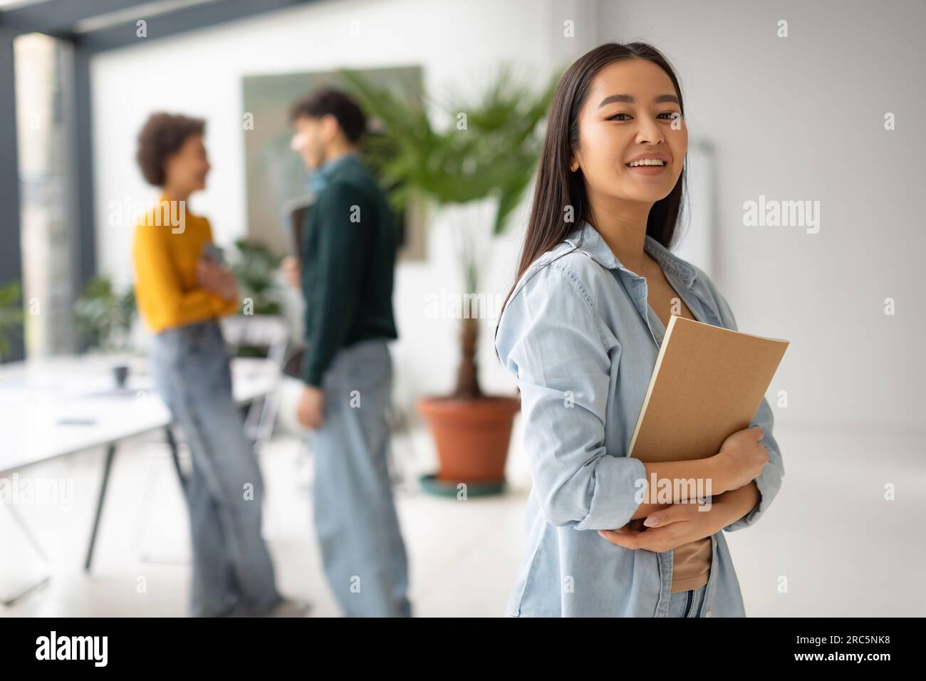 Happy asian student lady posing in university classroom and smiling at ...