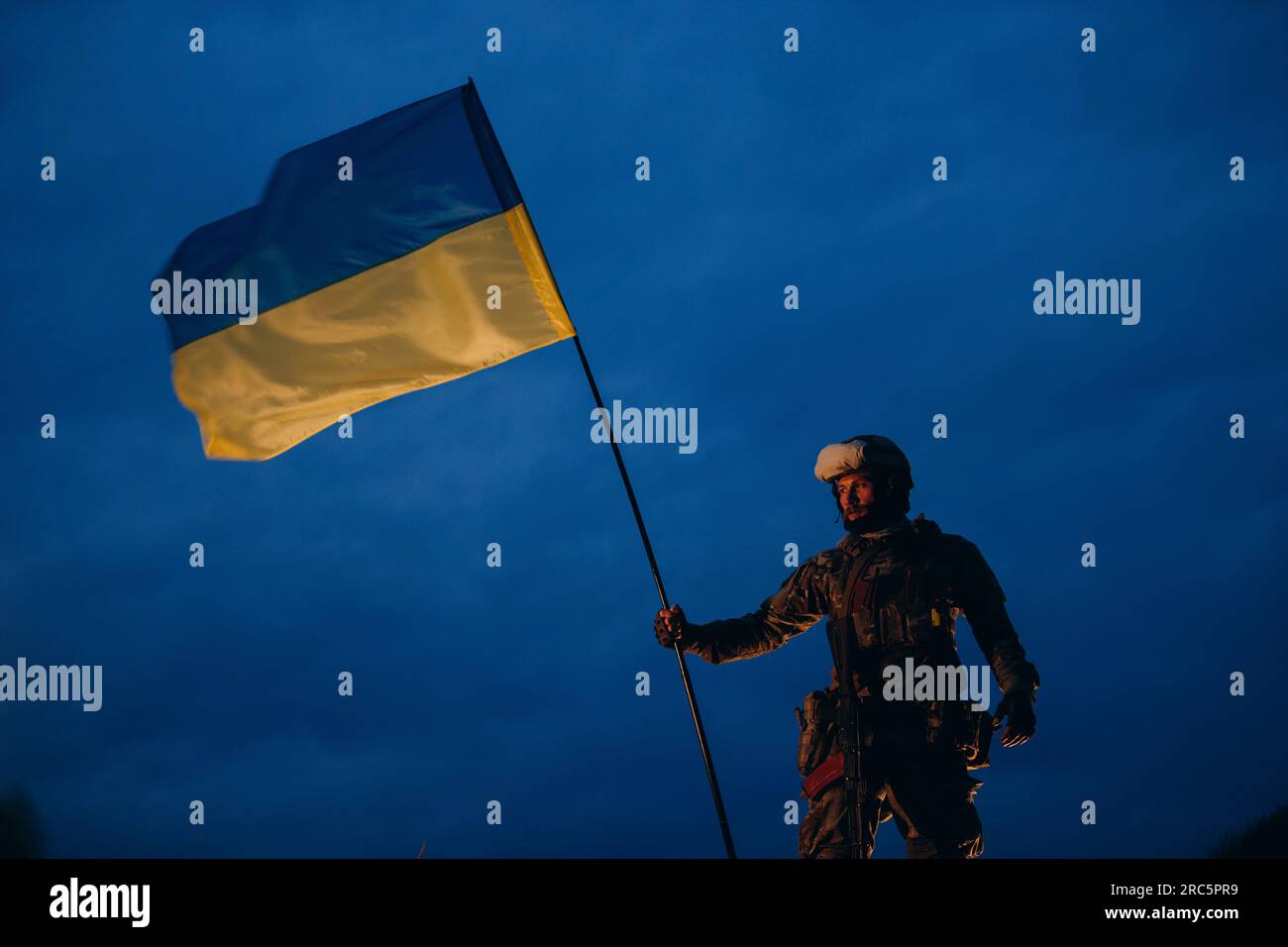 An evening photo of Ukrainian defender holding a national flag Stock ...