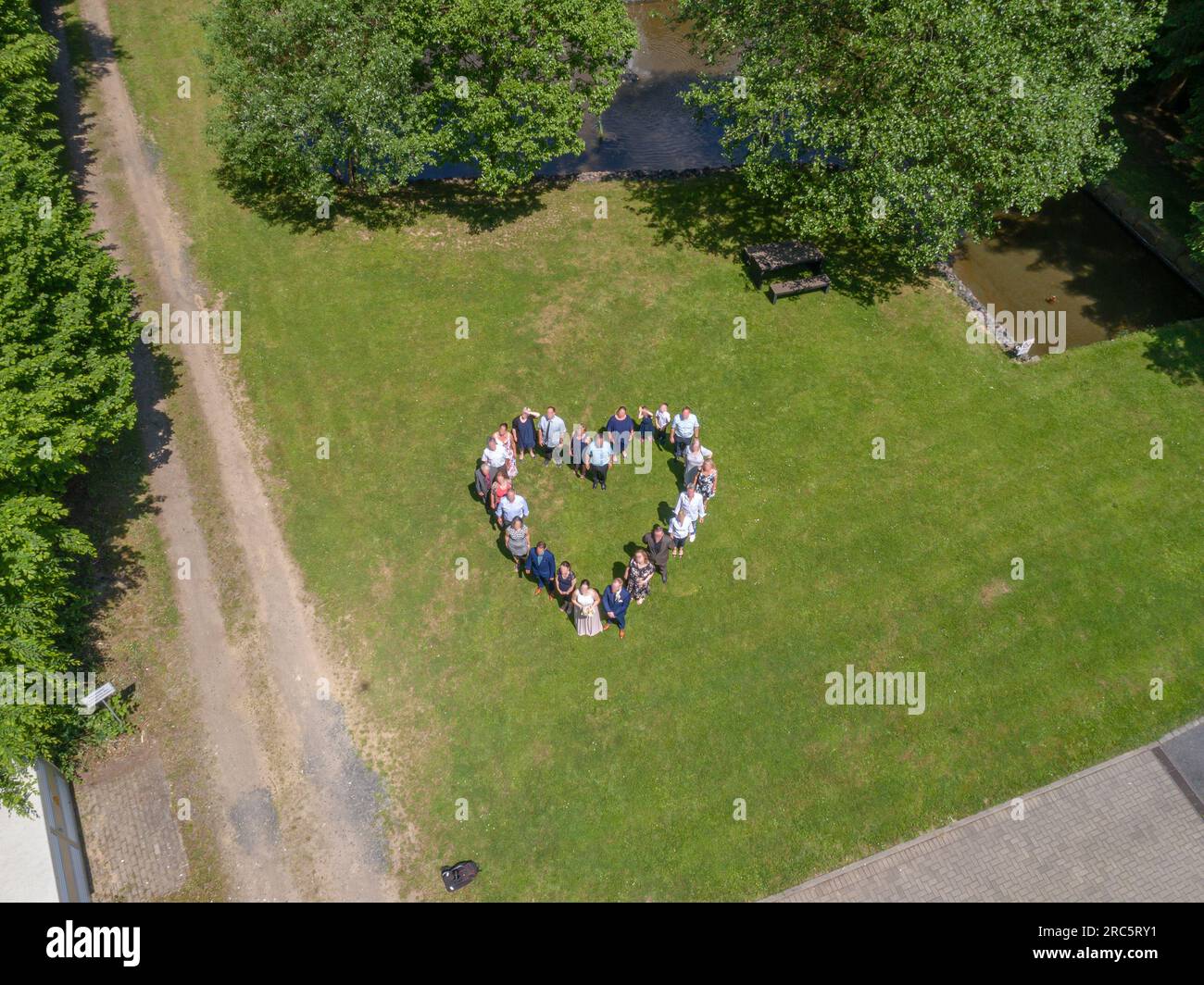 Wedding guests lined up in the shape of heart with bride and groom ...