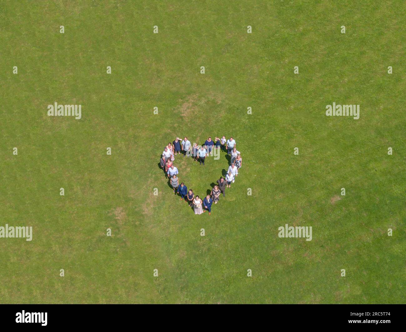 Wedding guests lined up in the shape of heart with bride and groom ...