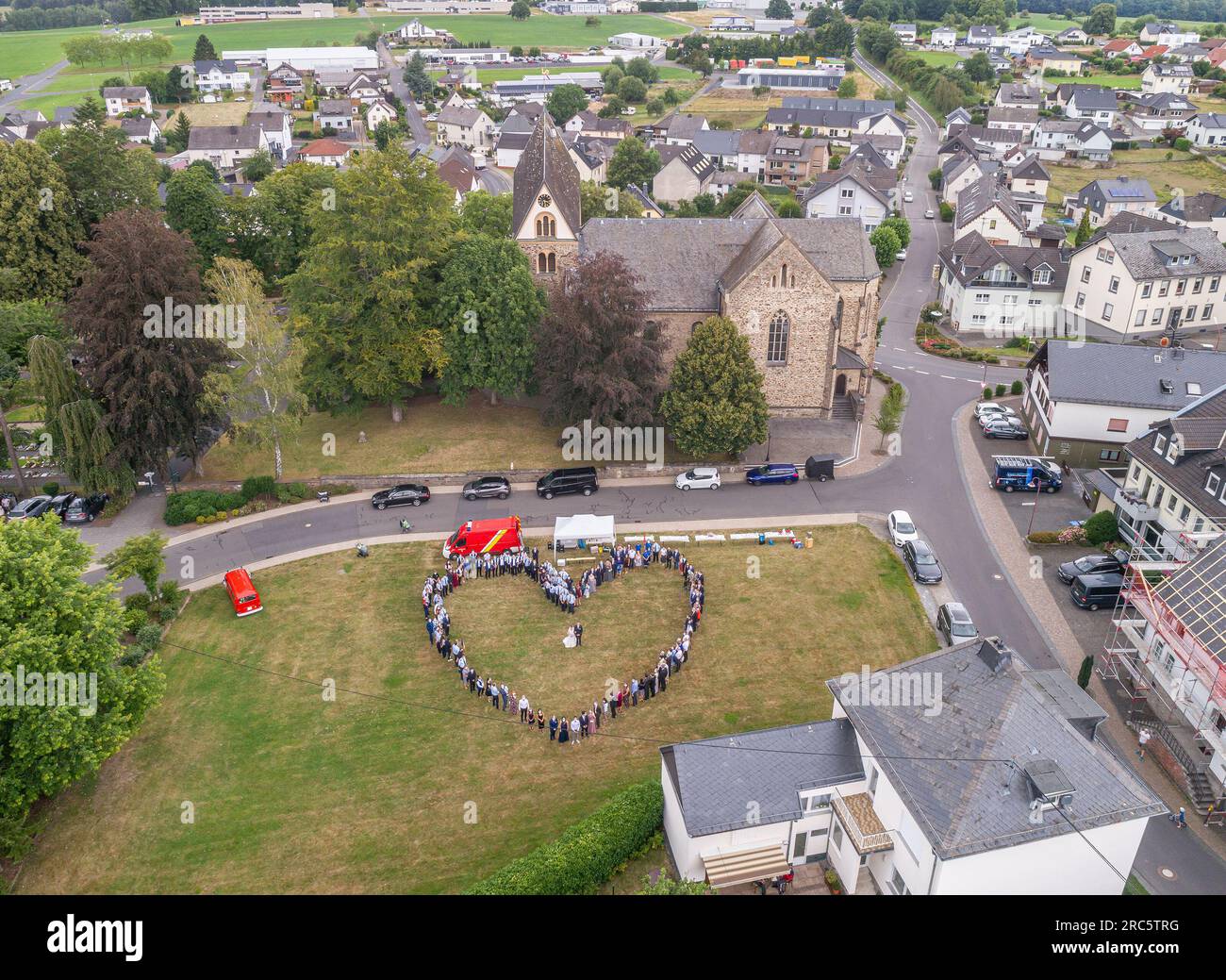 Wedding guests lined up in the shape of heart with bride and groom ...