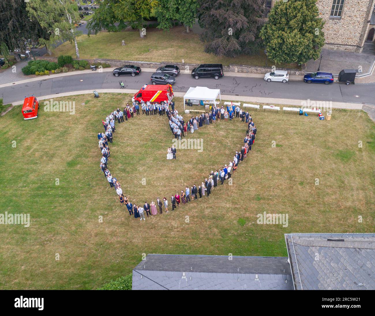 Wedding guests lined up in the shape of heart with bride and groom ...