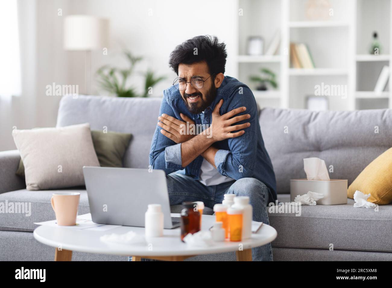 Fever Concept. Sick Young Indian Man Sitting On Couch And Freezing ...