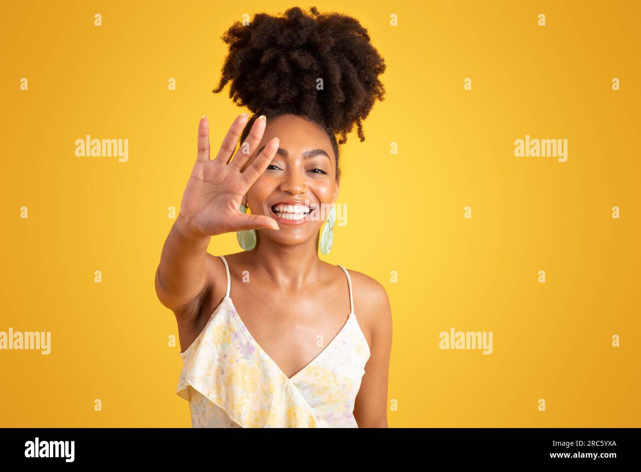 Laughing millennial african american lady holding out hand to camera ...