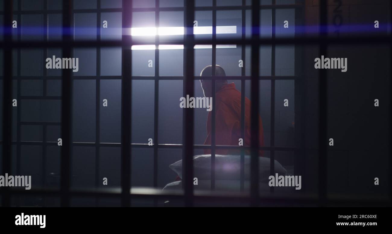 Elderly Criminal In Orange Uniform Sits In Jail Cell Stands Up And
