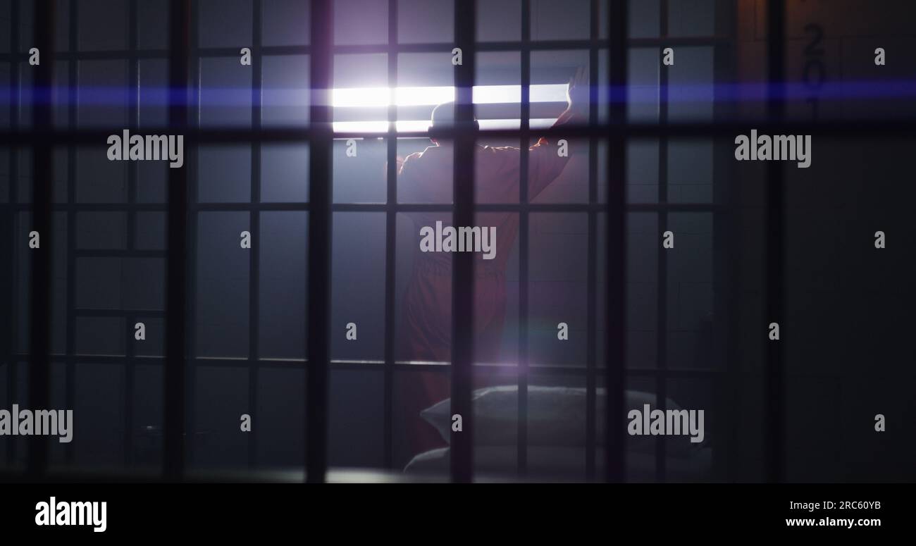 Elderly Criminal In Orange Uniform Sits In Jail Cell Stands Up And