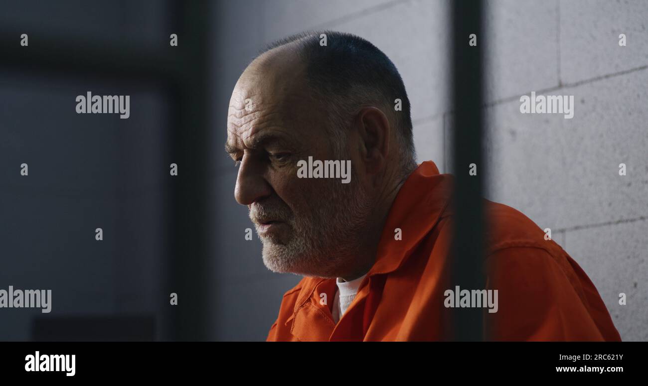 Elderly criminal in orange uniform sits on prison bed and dreams about ...