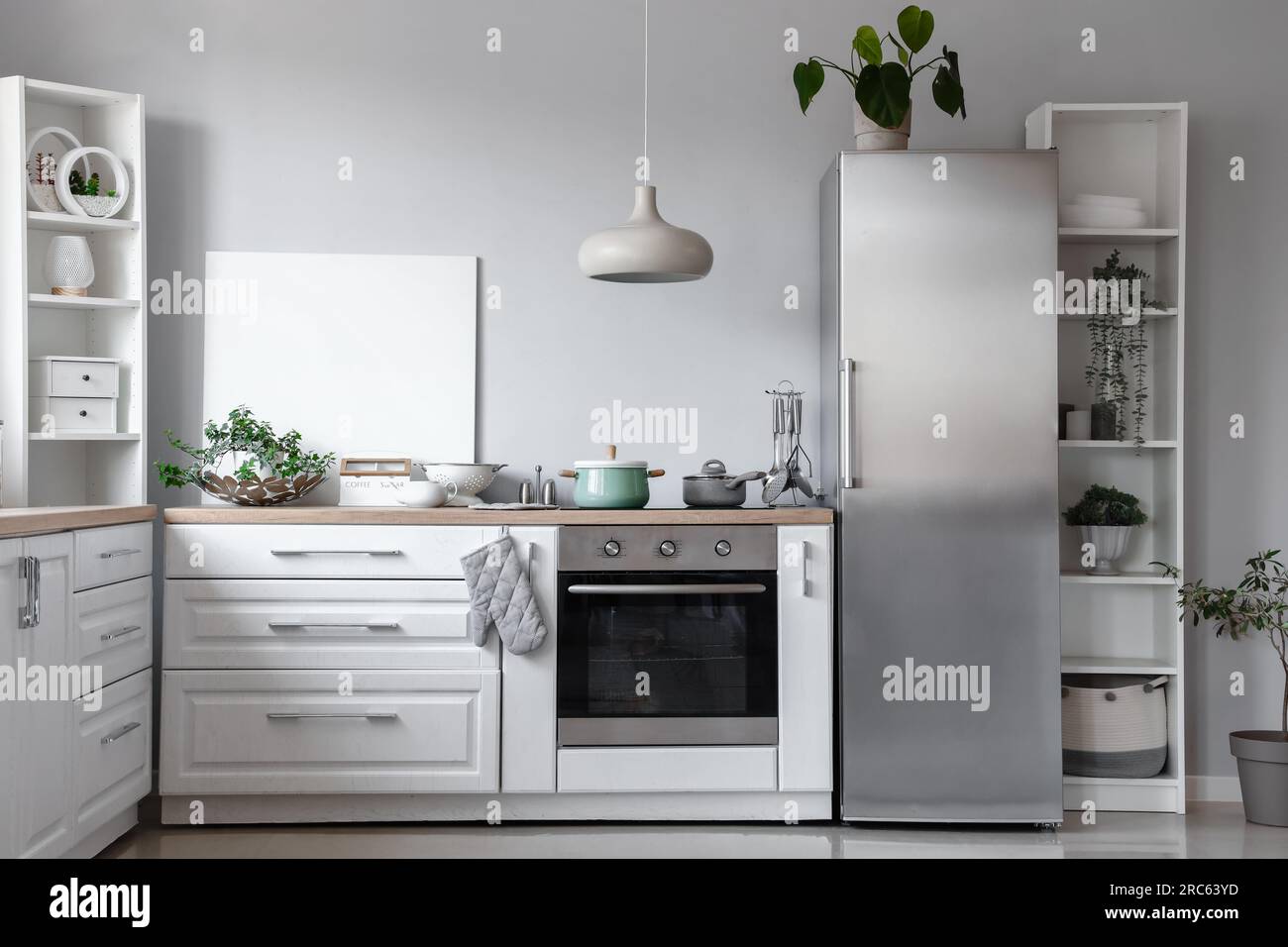Interior of light kitchen with stylish fridge, counters and shelving ...