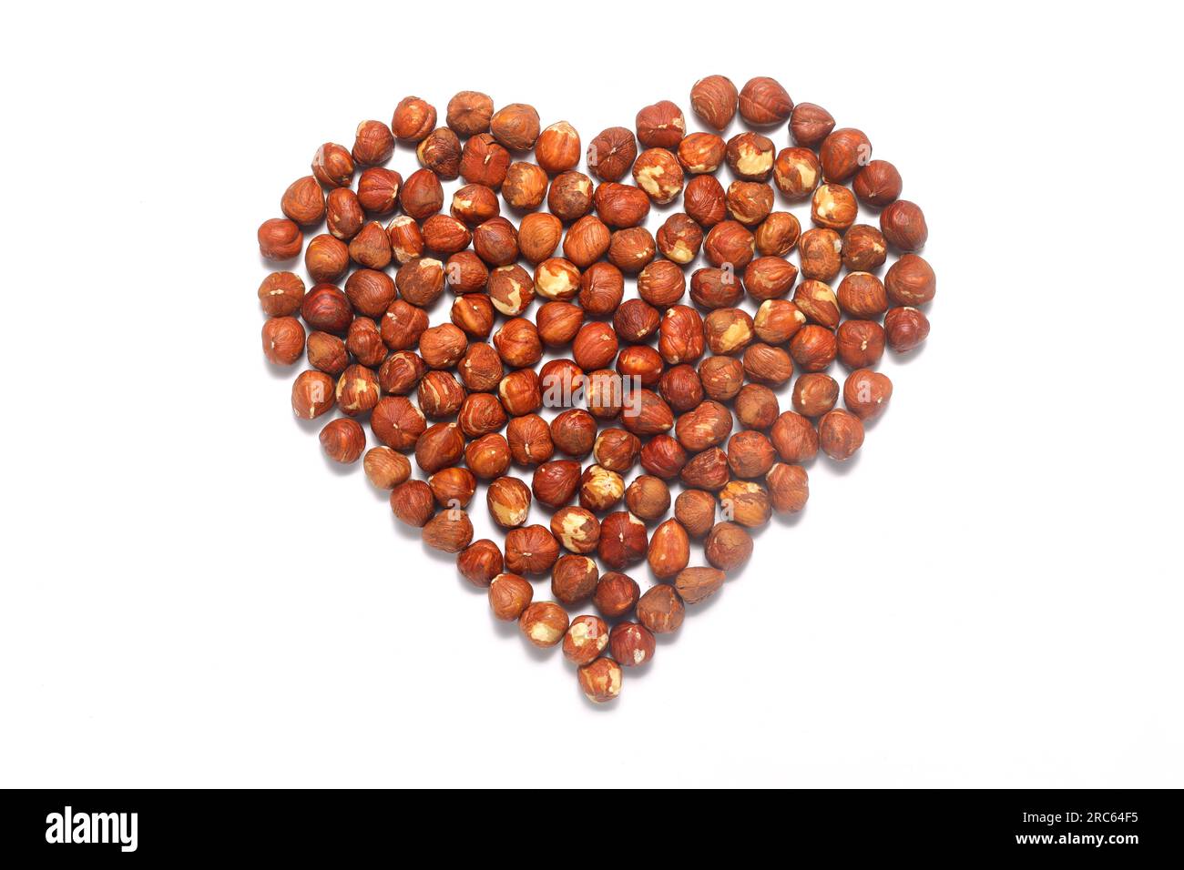 Heart shape made of nuts. Brown hazelnut kernels on a white background ...