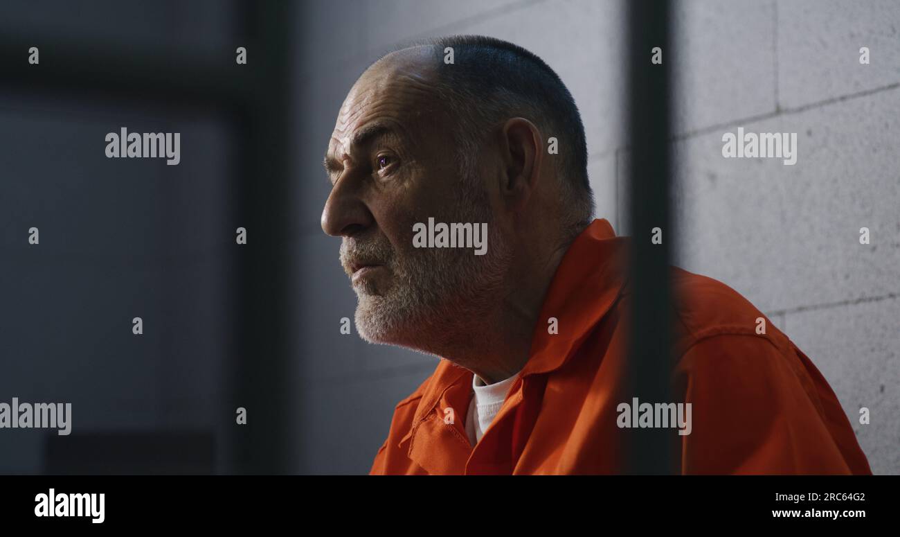 Elderly criminal in orange uniform sits on prison bed and dreams about ...