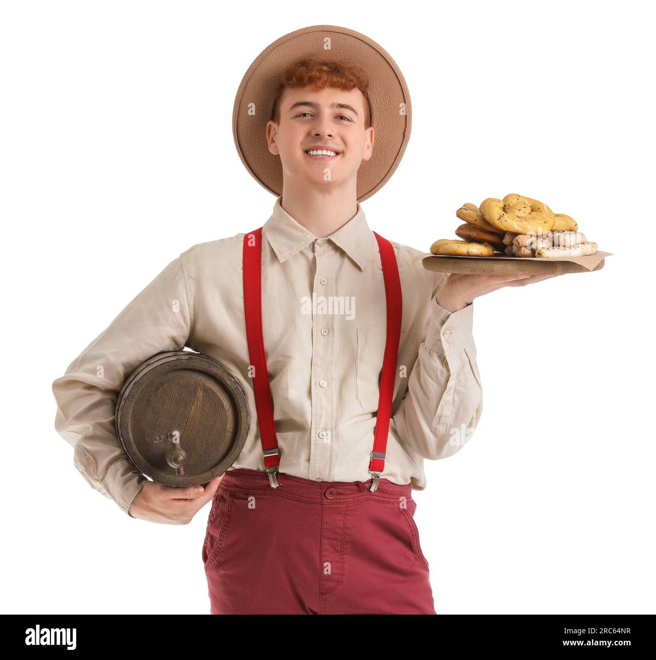 Young man in traditional German clothes with barrel and snacks on white ...