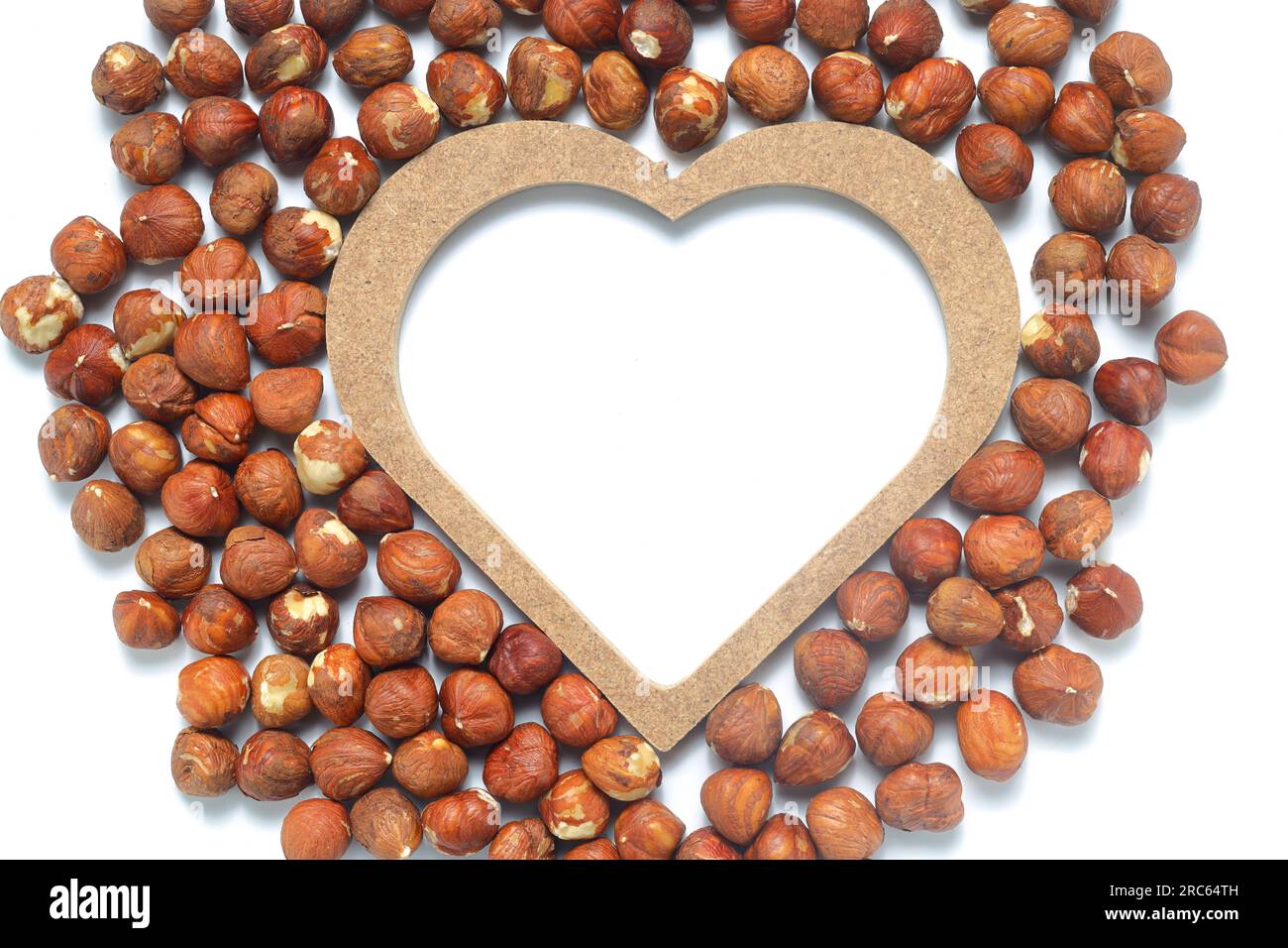 Heart shape made of nuts. Brown hazelnut kernels on a white background ...