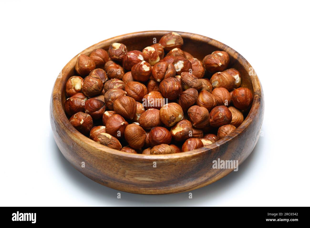 Wooden bowl full of hazelnuts on white background. Healthy eating ...