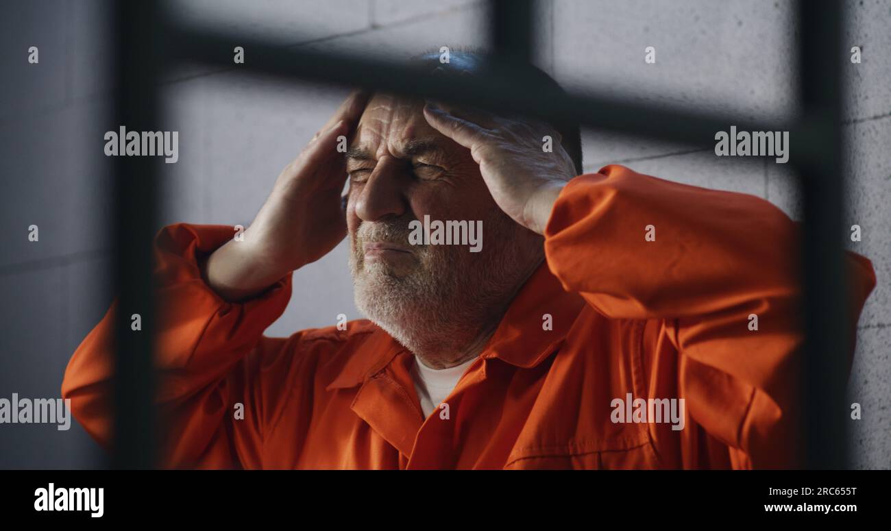 Senior criminal in orange uniform sits on prison bed and dreams about ...