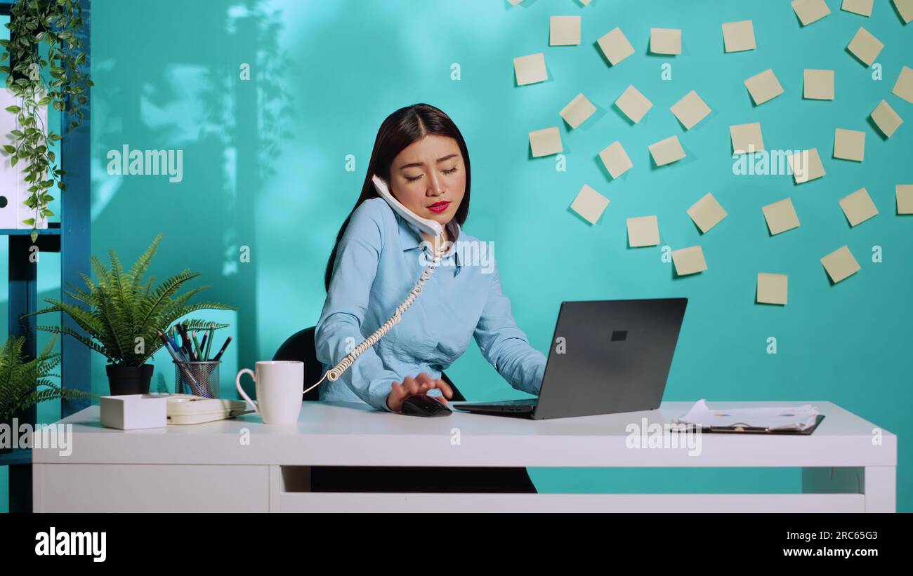 Busy administrative asian executive chatting in landline call while ...