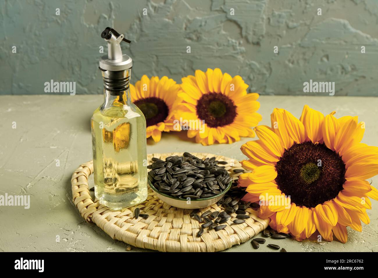 Sunflowers, seeds and bottle of oil on green background Stock Photo - Alamy
