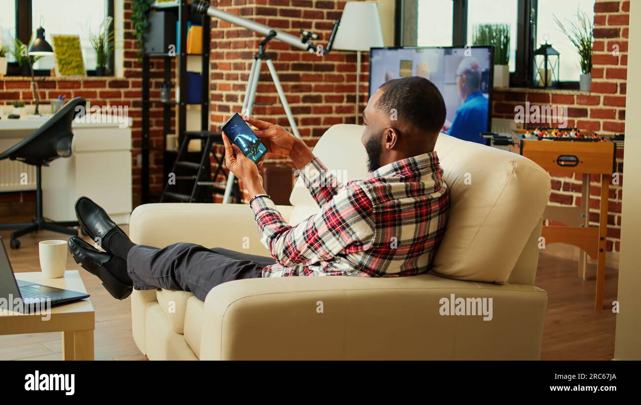 Happy gamer playing spaceship flying game on smartphone, using ...