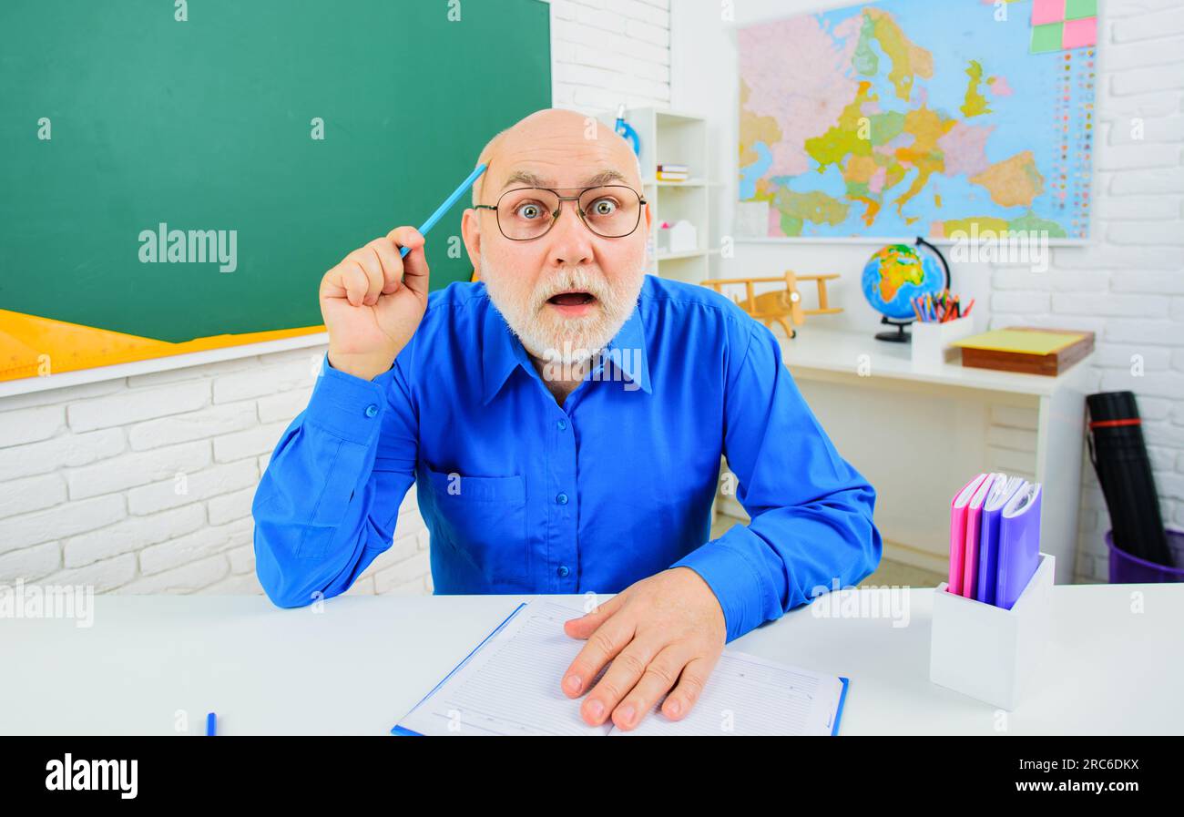 Surprised bearded teacher at desk in classroom. Knowledge day. Bearded ...
