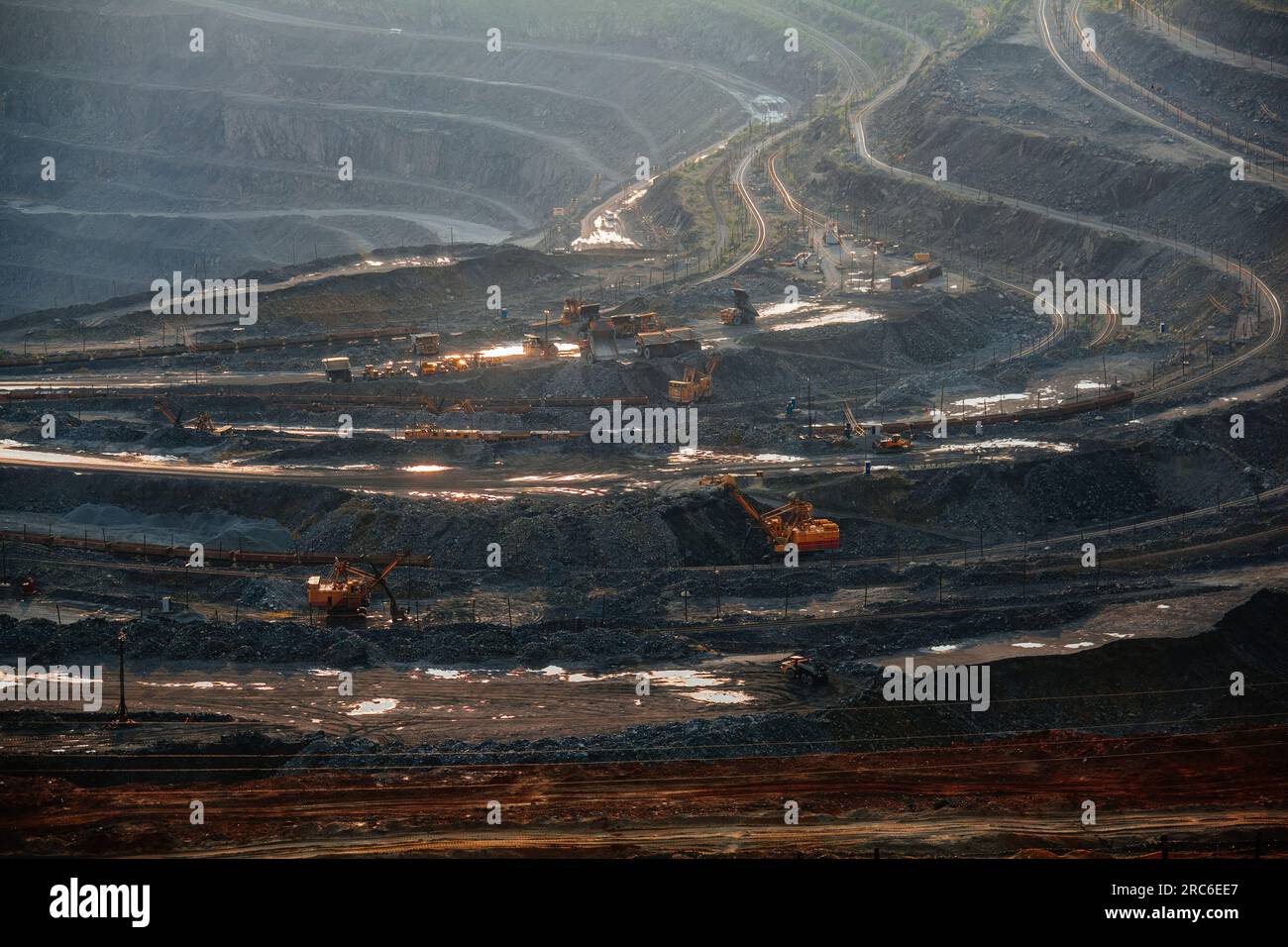 Excavators and dump trucks working on earthmoving at open pit mine in ...