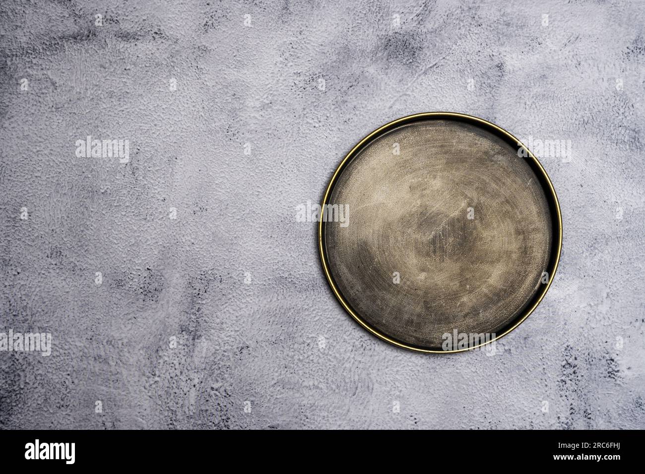 A vintage metal plate with a gold edge on a grainy surface Stock Photo ...