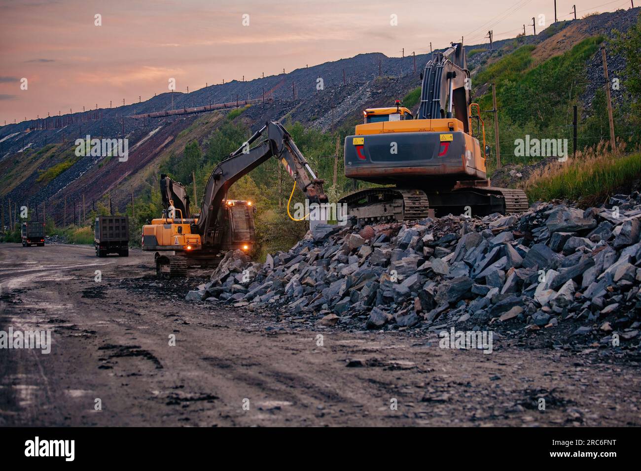 Excavators and dump trucks working on earthmoving at open pit mine in ...