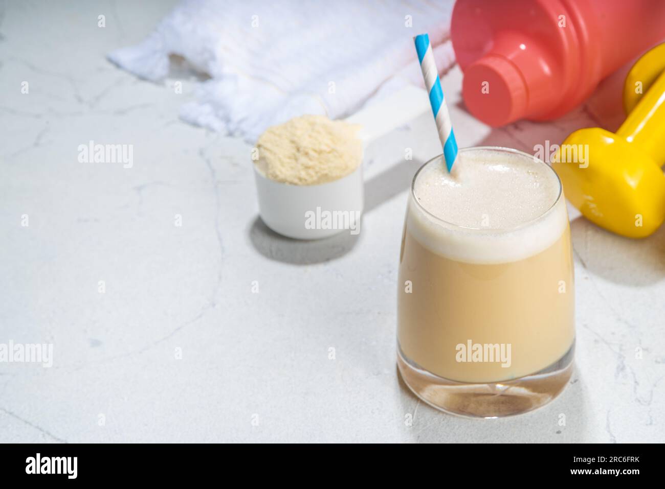 Vanilla white protein shake glass, with straw, with protein powder ...