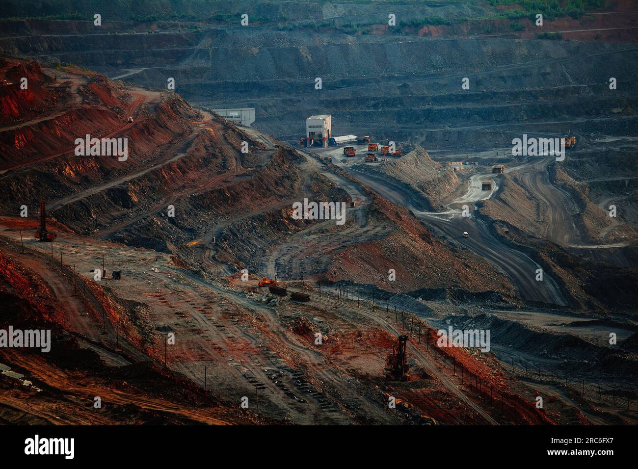 Excavators and dump trucks working on earthmoving at open pit mine in ...