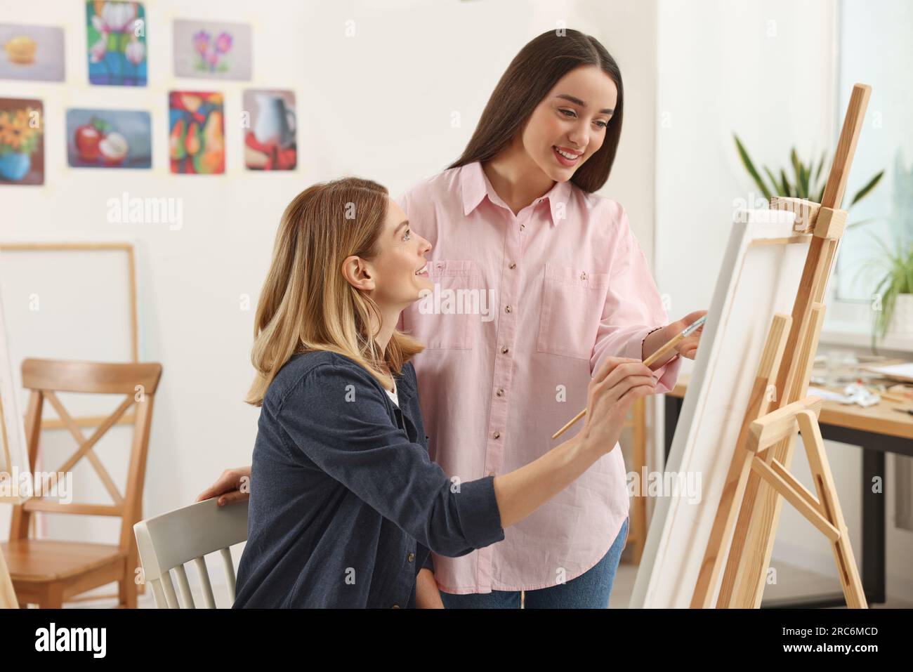 Artist teaching her student to paint in studio. Creative hobby Stock ...