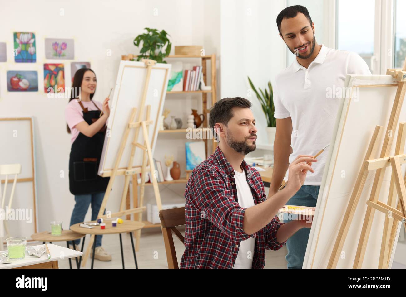 Artist and her students having painting class in studio. Creative hobby ...