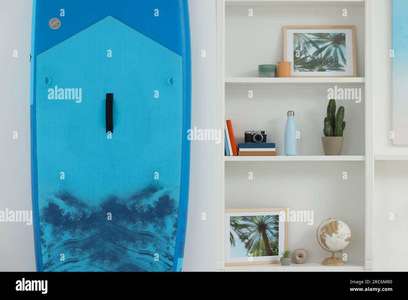 SUP board and shelving unit with different decor elements in room ...