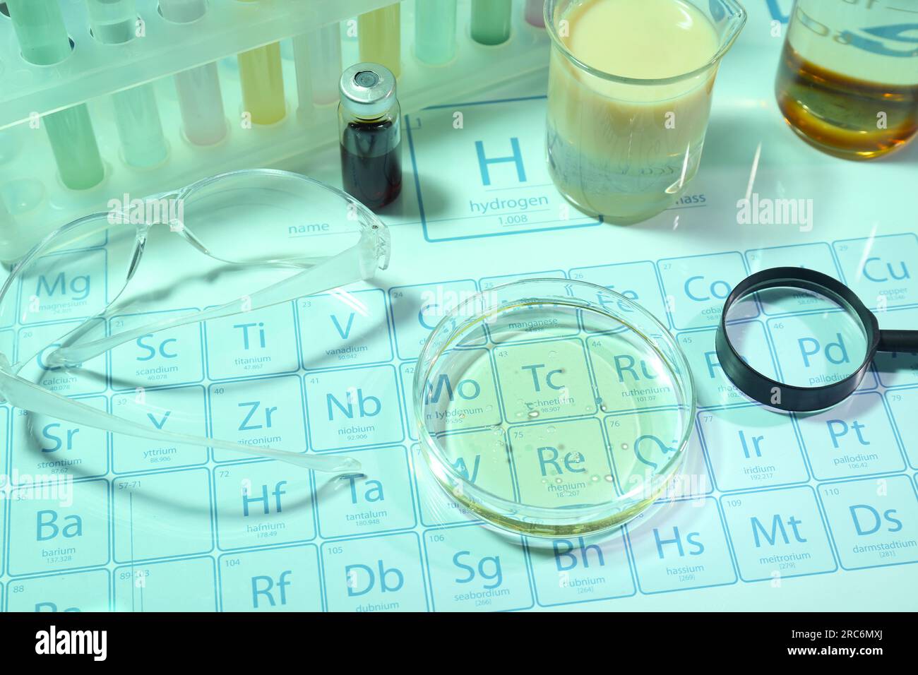 Different laboratory equipment with liquids and safety glasses on ...