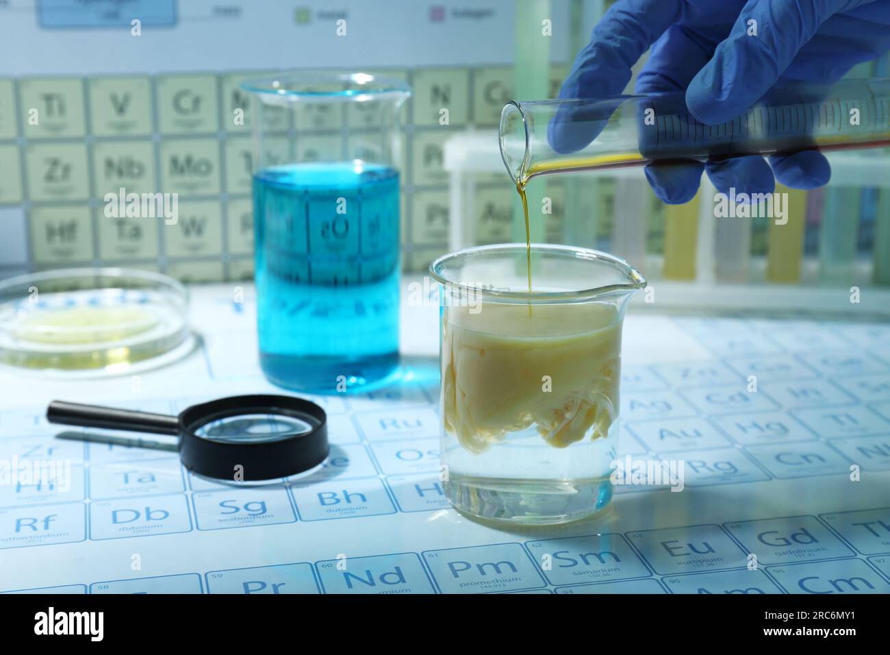 Scientist pouring liquid from test tube into beaker, different ...