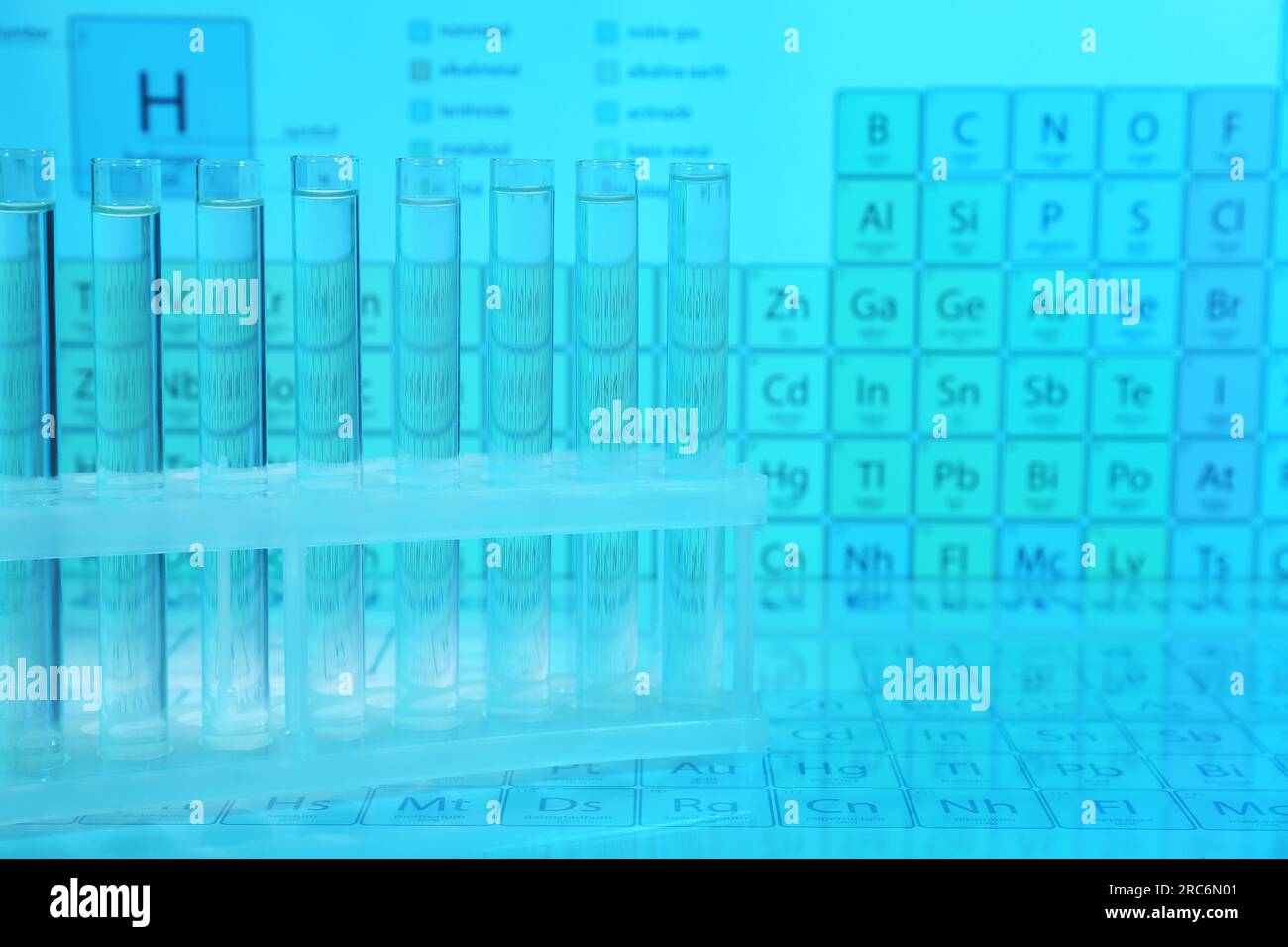 Test tubes against periodic table of elements, toned in light blue ...